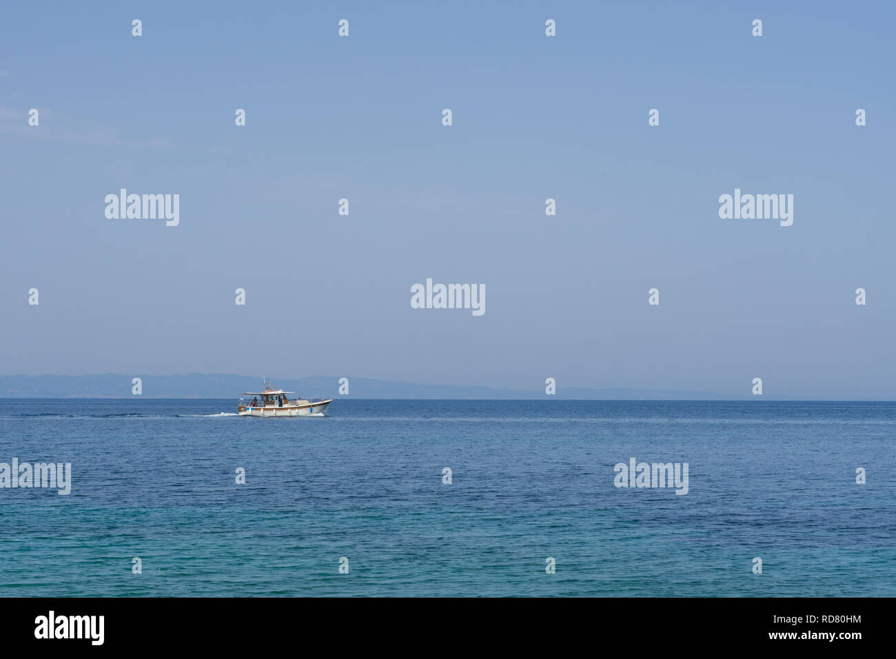 Small white motorized boat with one man sails in the open sea Stock ...