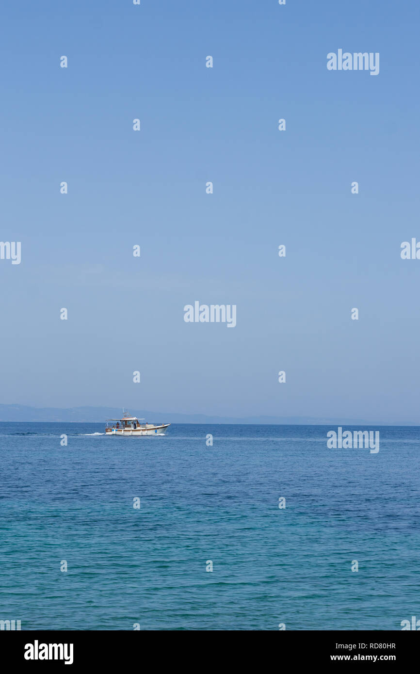 Small white motorized boat with one man sails in the open sea Stock ...