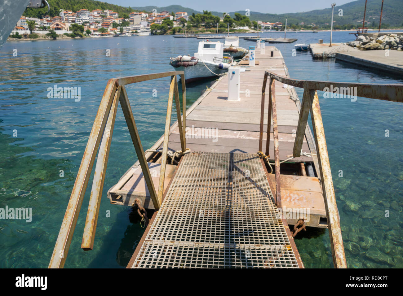 A metal bridge leading to the dock with boats Stock Photo - Alamy
