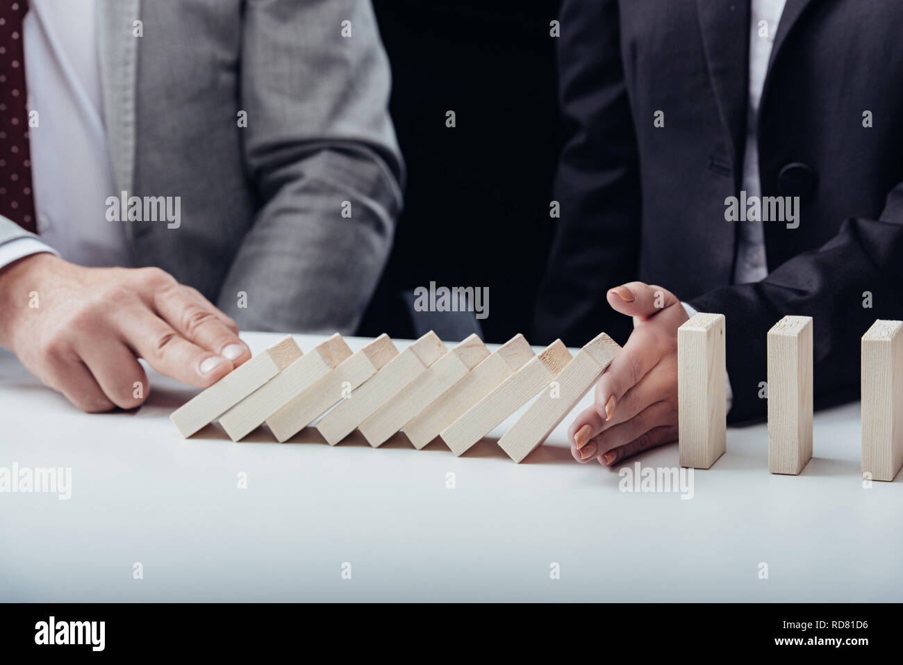 partial view of man pushing wooden bricks while woman preventing row ...