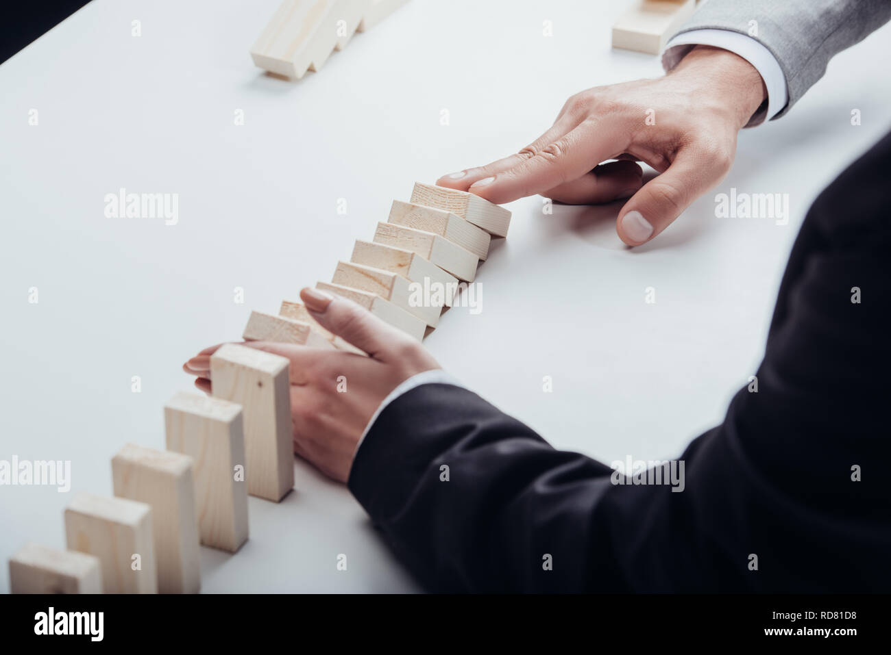 partial view of man pushing wooden bricks while woman preventing row ...