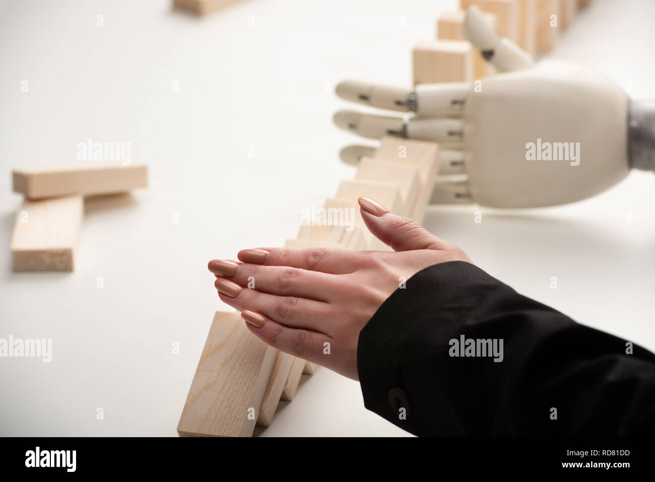 partial view of woman pushing wooden bricks while robotic hand ...