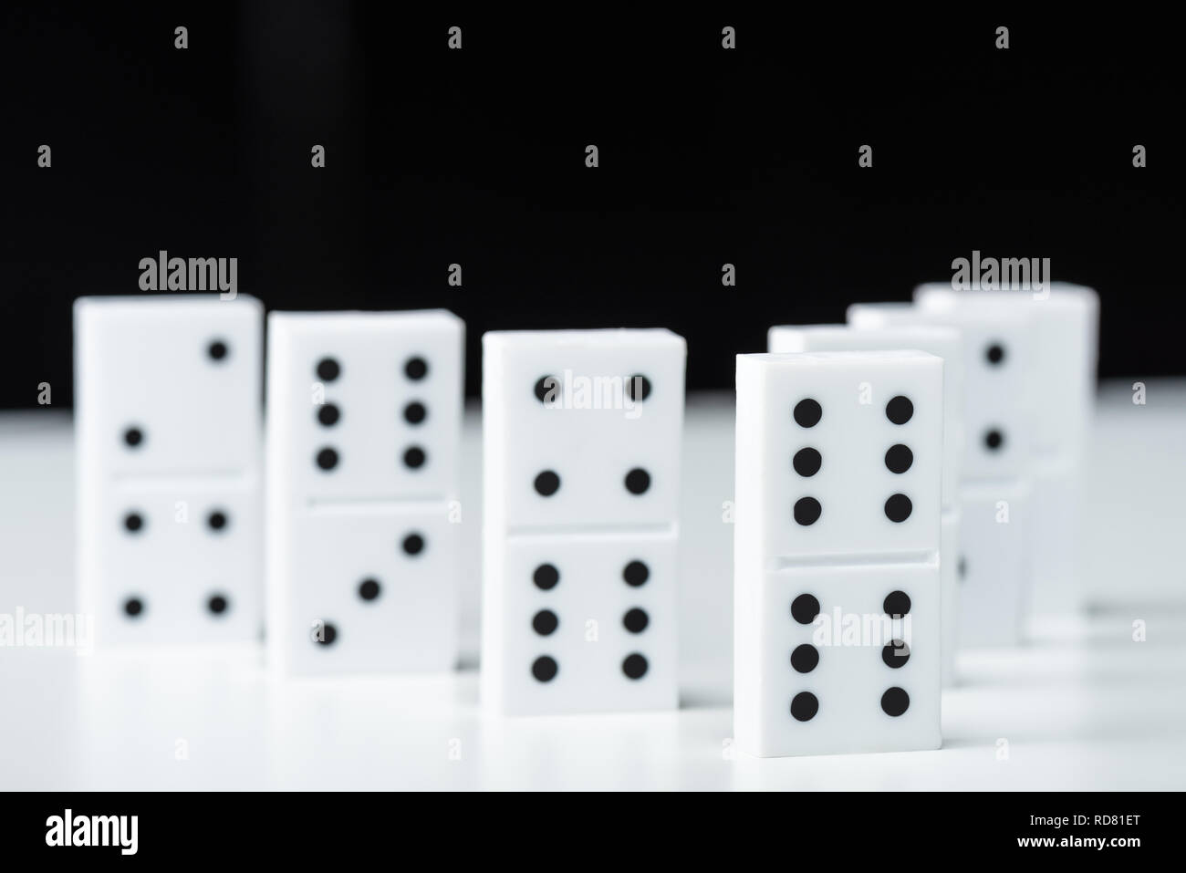 selective focus of domino row isolated on black Stock Photo - Alamy