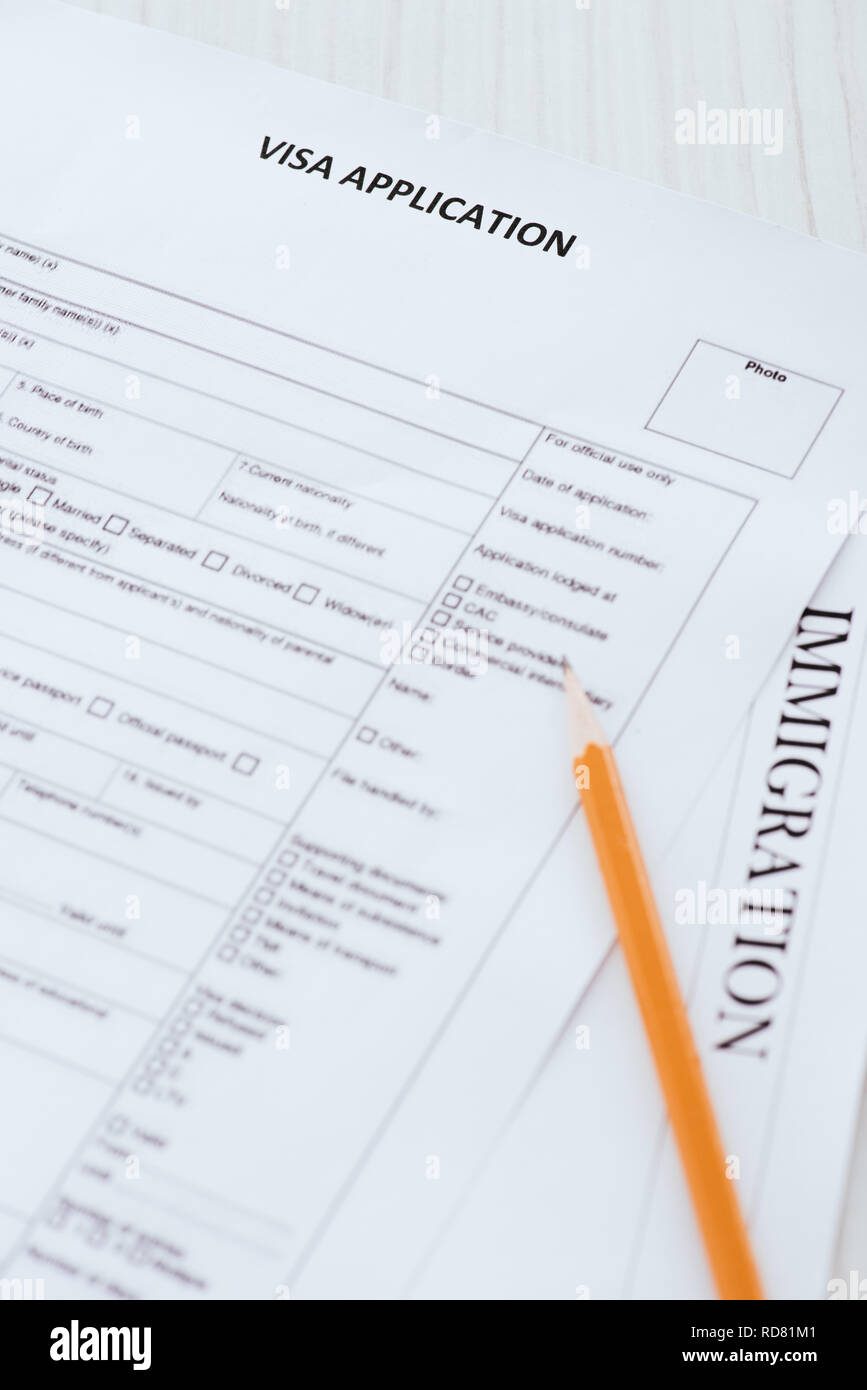 pencil near documents with visa application and immigration lettering ...