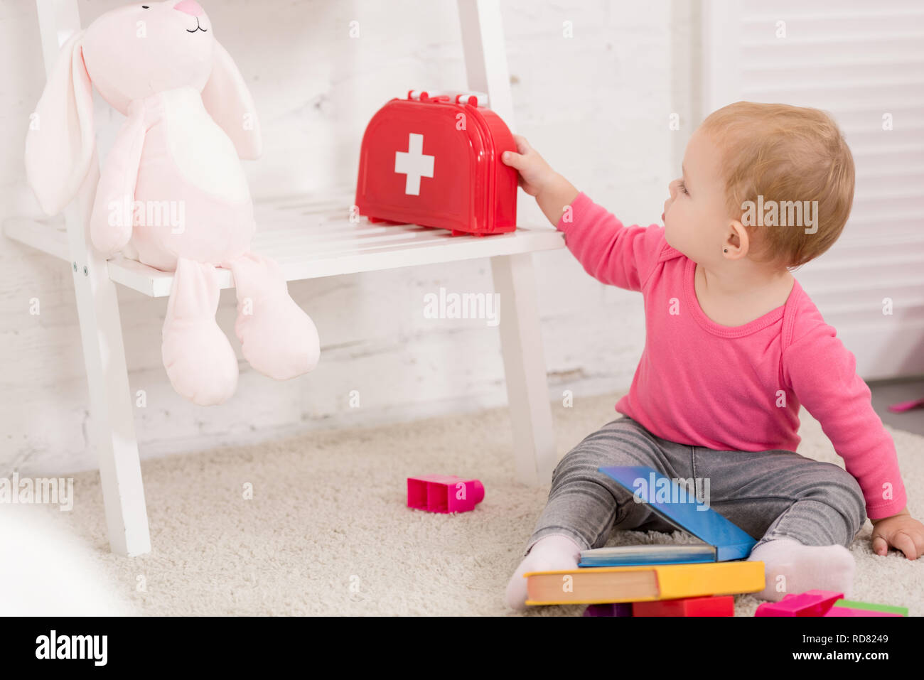 adorable kid taking first aid kit in children room Stock Photo - Alamy