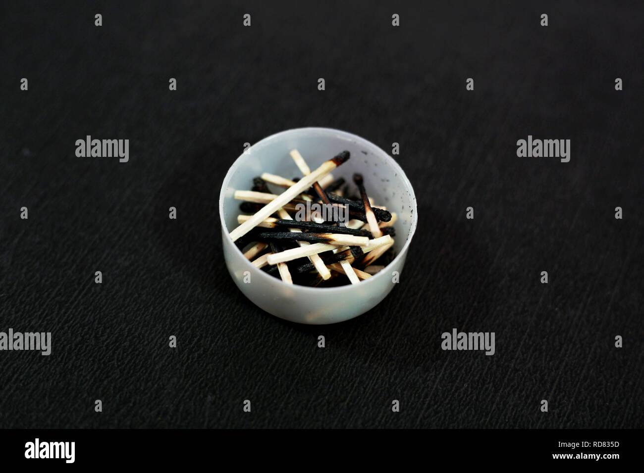 Picture of burned matchstick in the small pot. Isolated on the black ...