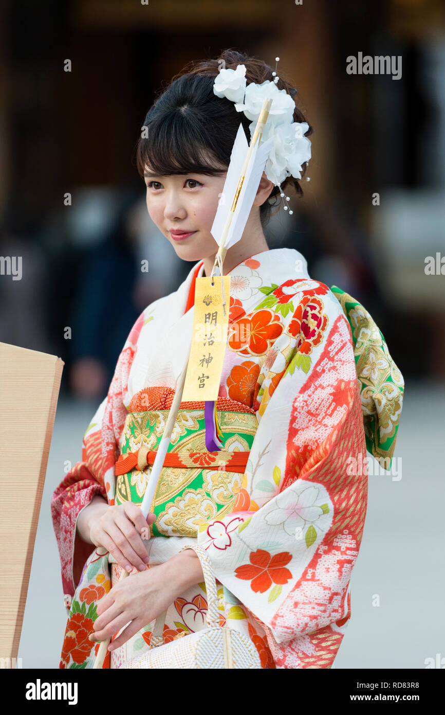 Young woman in a kimono holding a hamaya on Coming of Age Day at Meiji ...
