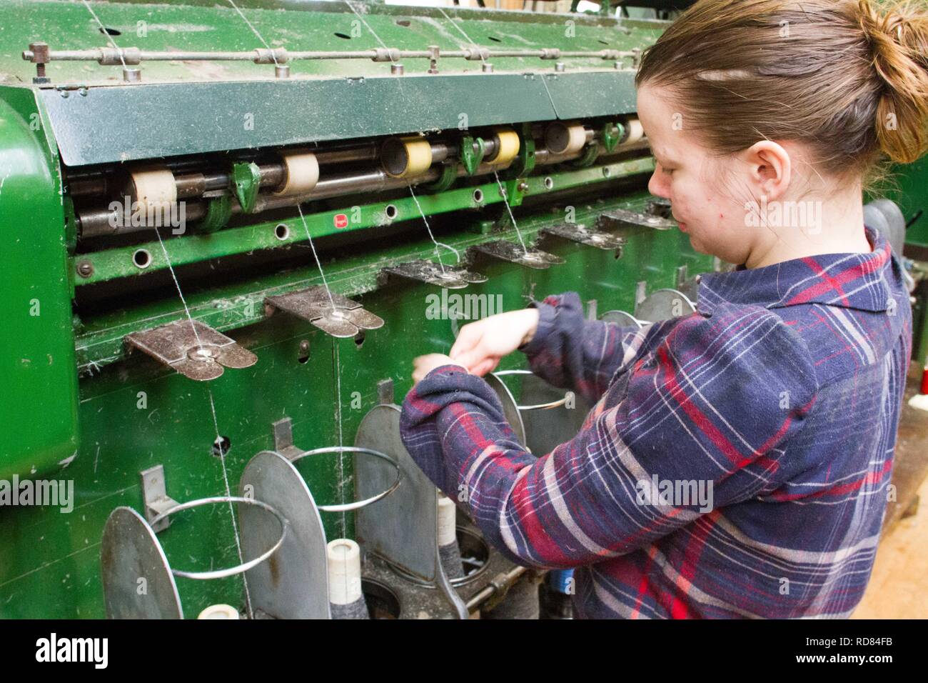 Highly skilled Swedish woman using restored wool and textile machines ...