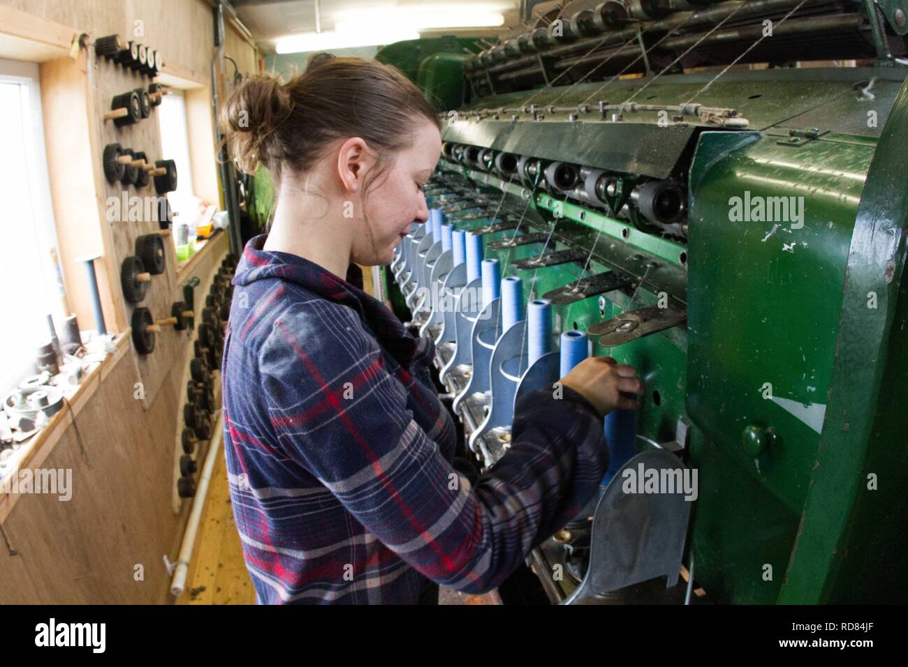 Highly skilled Swedish woman using restored wool and textile machines ...