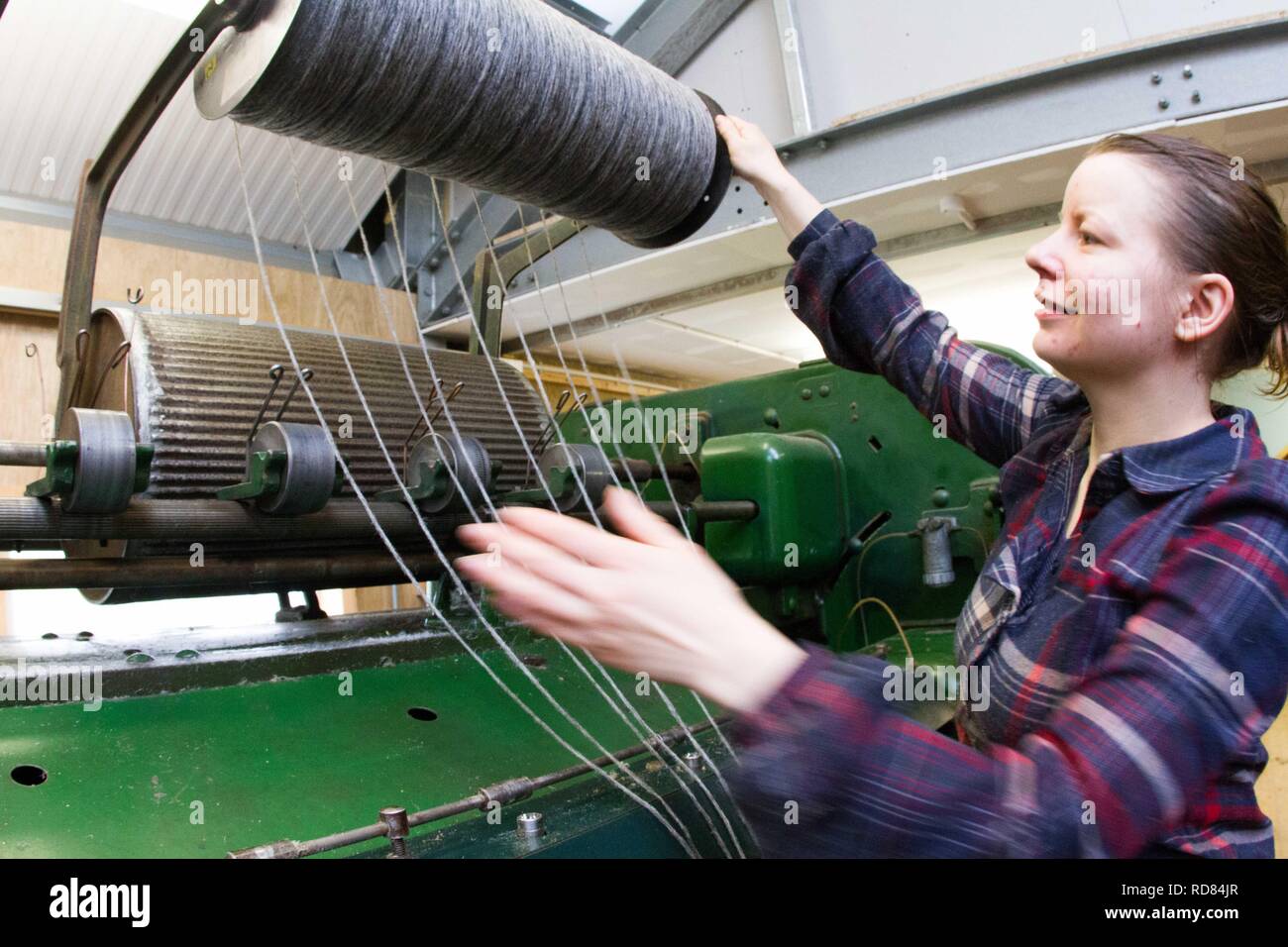 Highly skilled Swedish woman using restored wool and textile machines ...