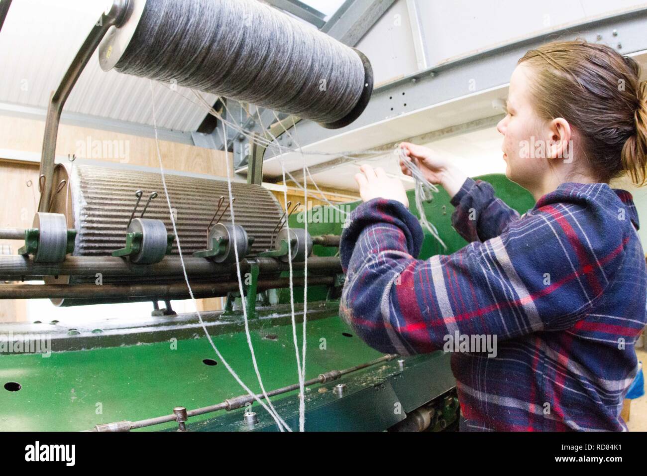 Highly skilled Swedish woman using restored wool and textile machines ...