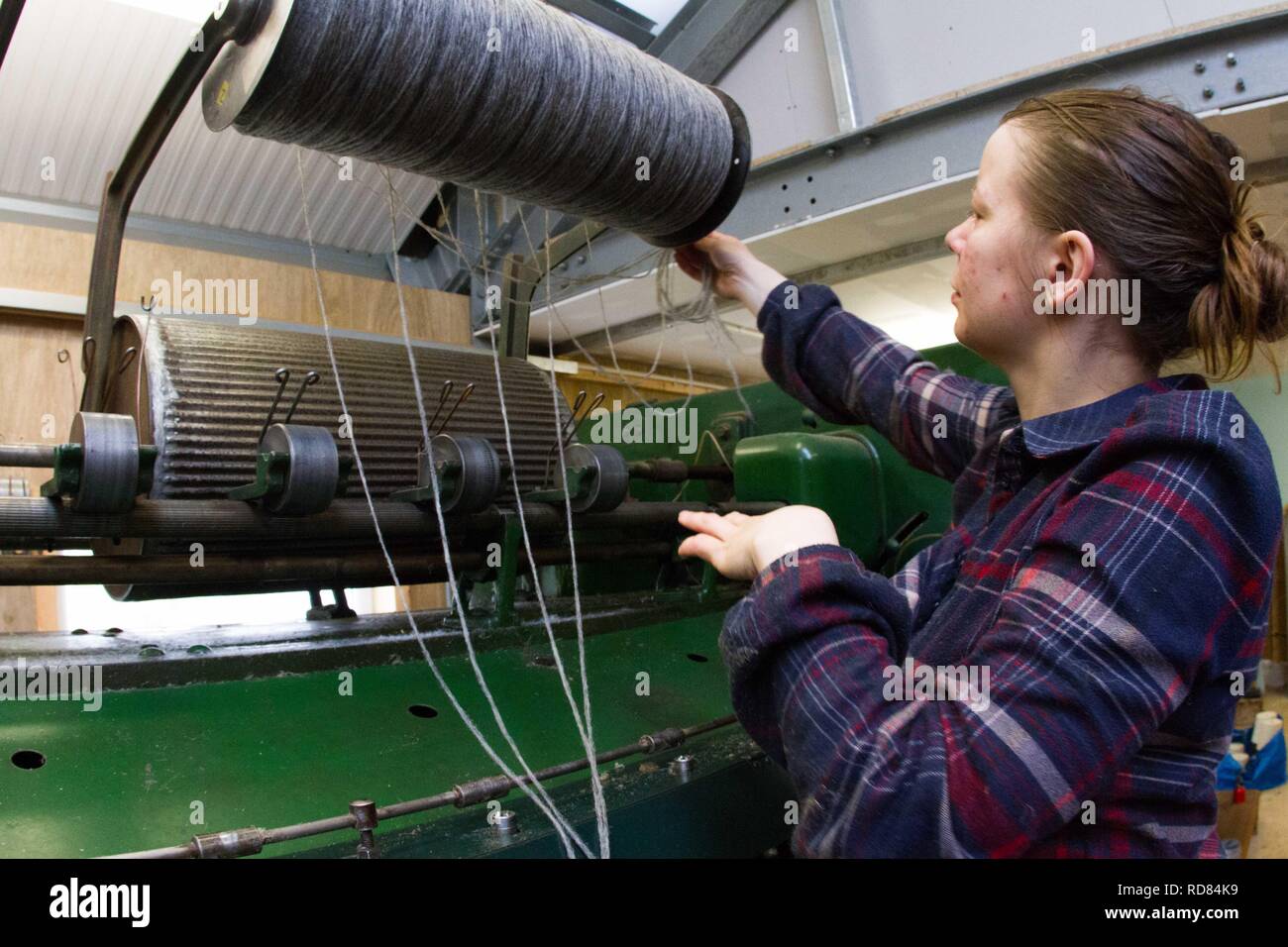 Highly skilled Swedish woman using restored wool and textile machines ...