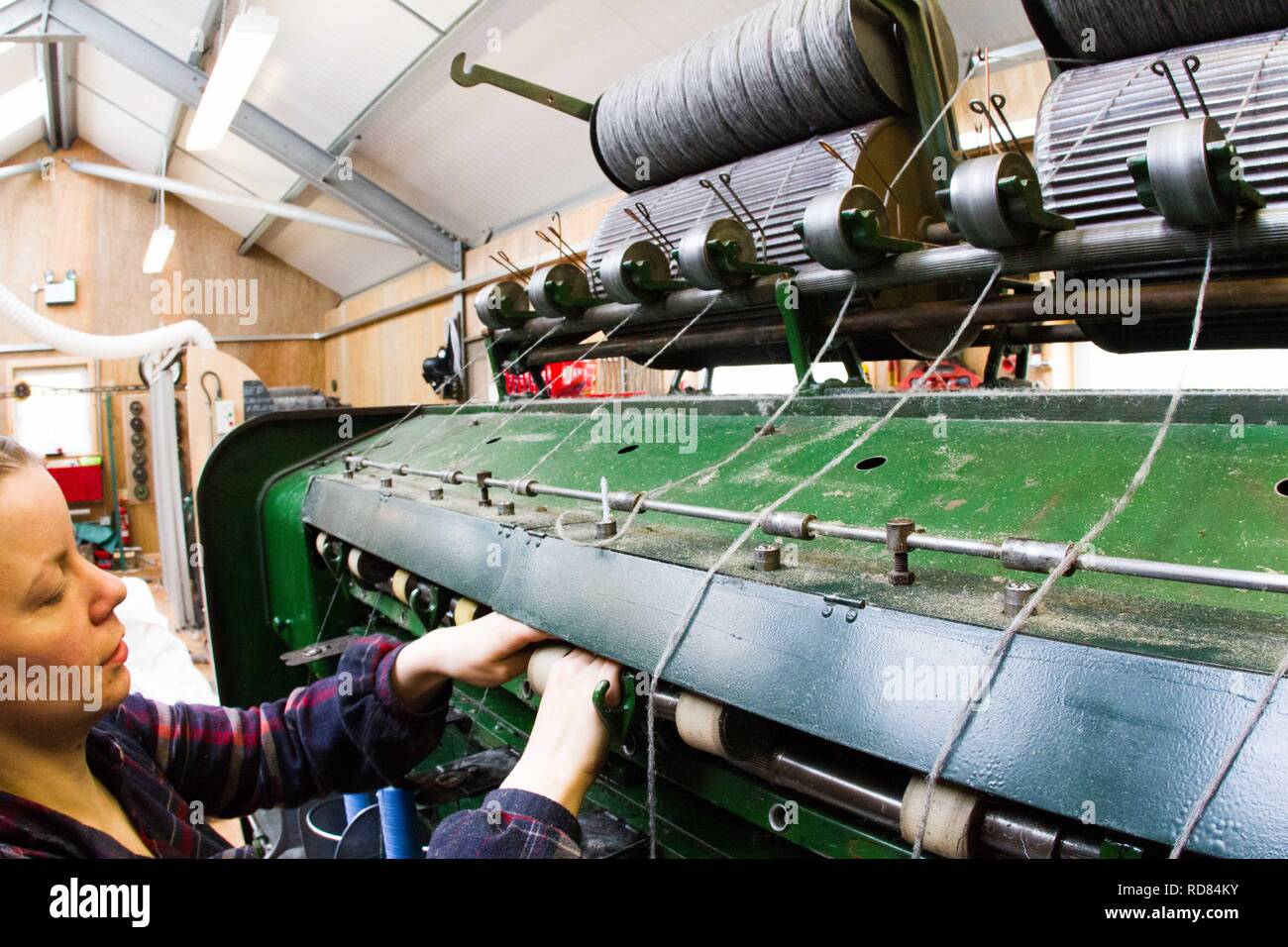 Highly skilled Swedish woman using restored wool and textile machines ...