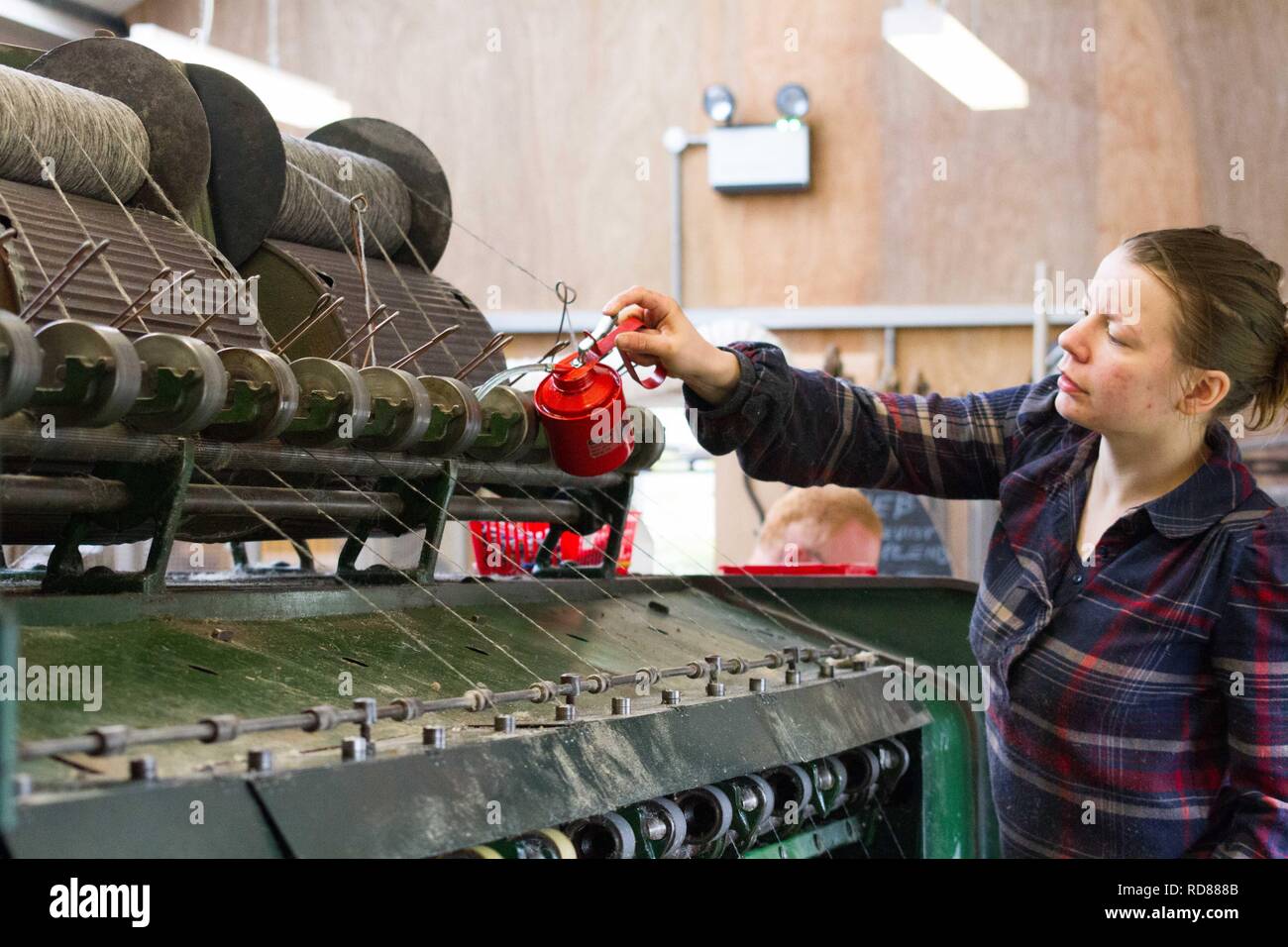 Highly skilled Swedish woman using restored wool and textile machines ...