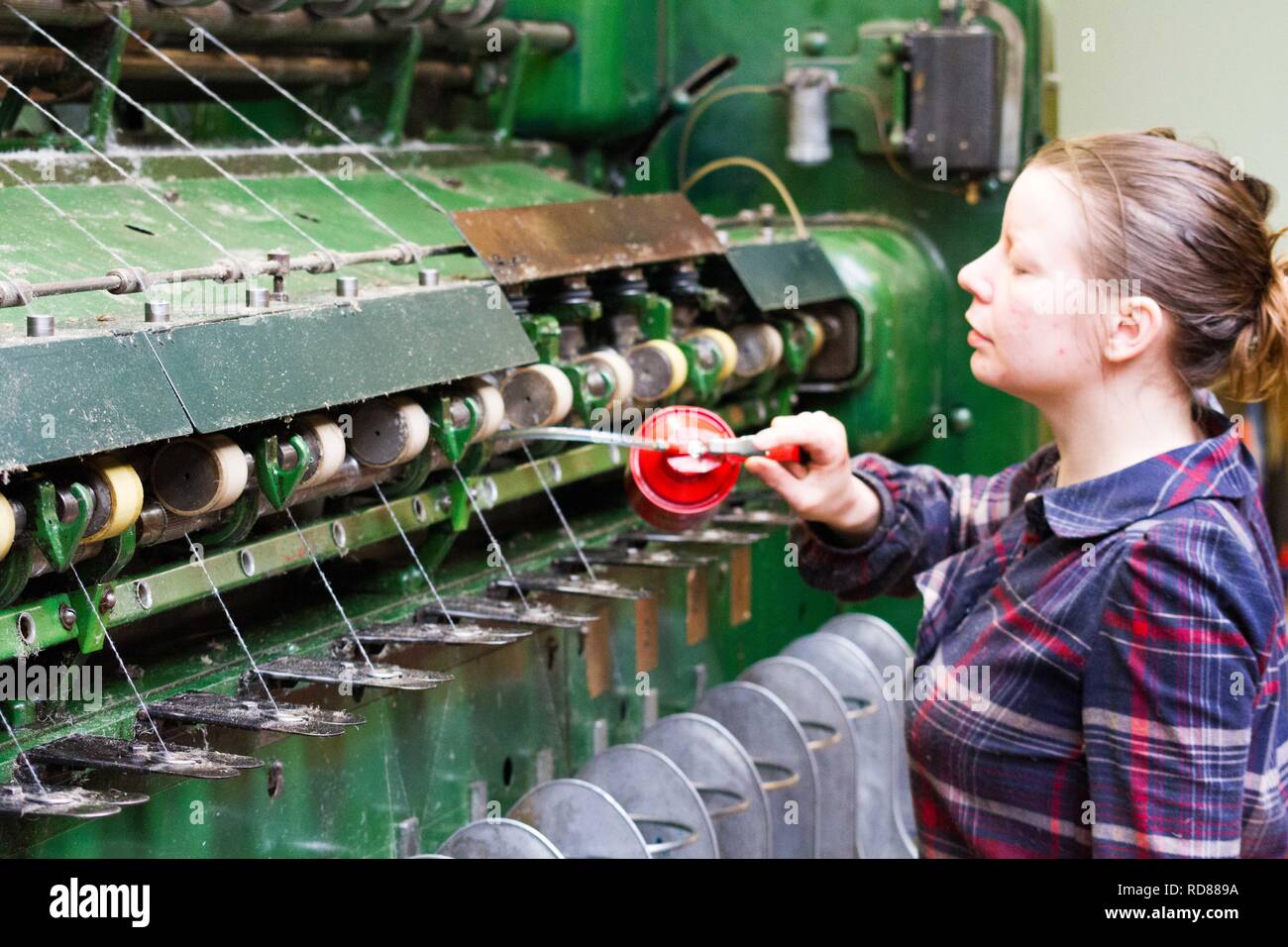 Highly skilled Swedish woman using restored wool and textile machines ...