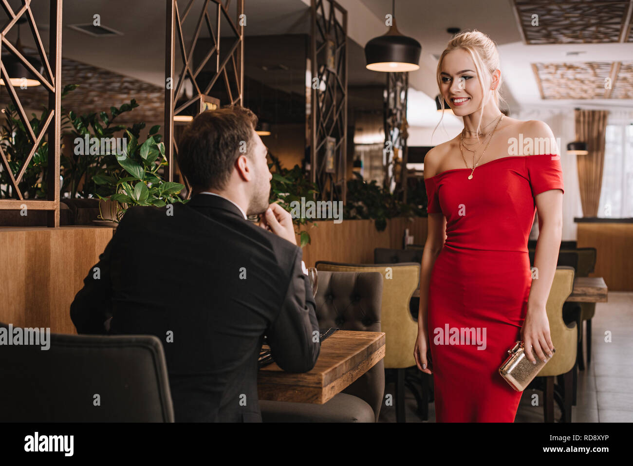 boyfriend looking at attractive smiling girlfriend in red dress Stock ...