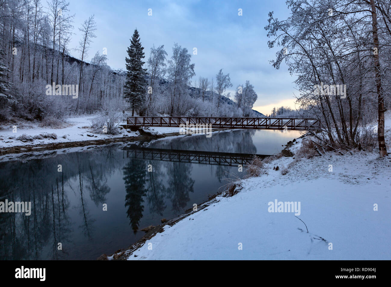 A soft evening light settles over the pedestrian bridge on a winter's ...