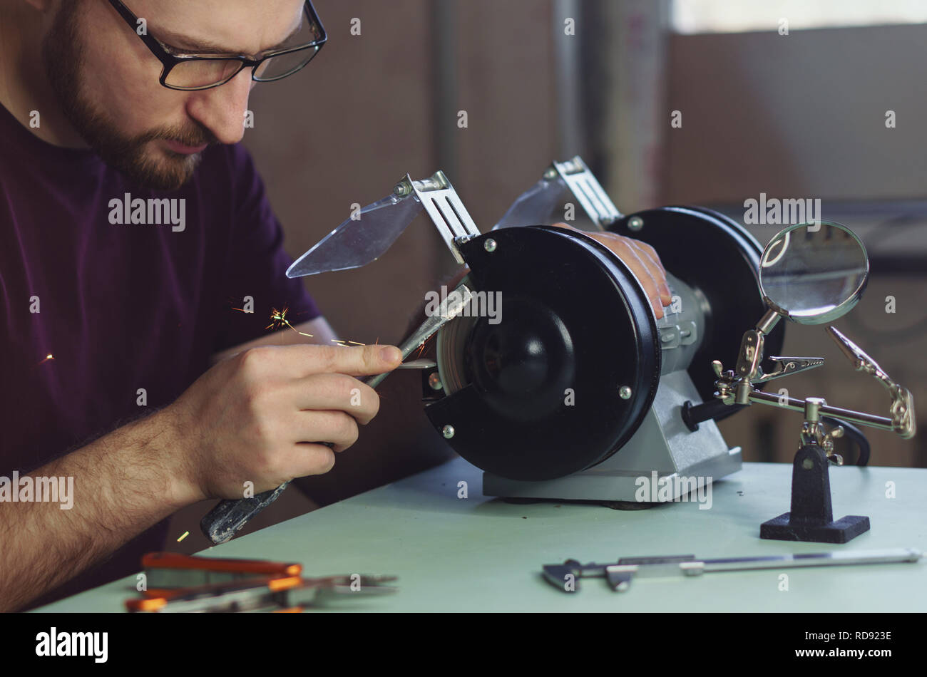 Master works for grinding machine. Man with glasses handles part Stock ...