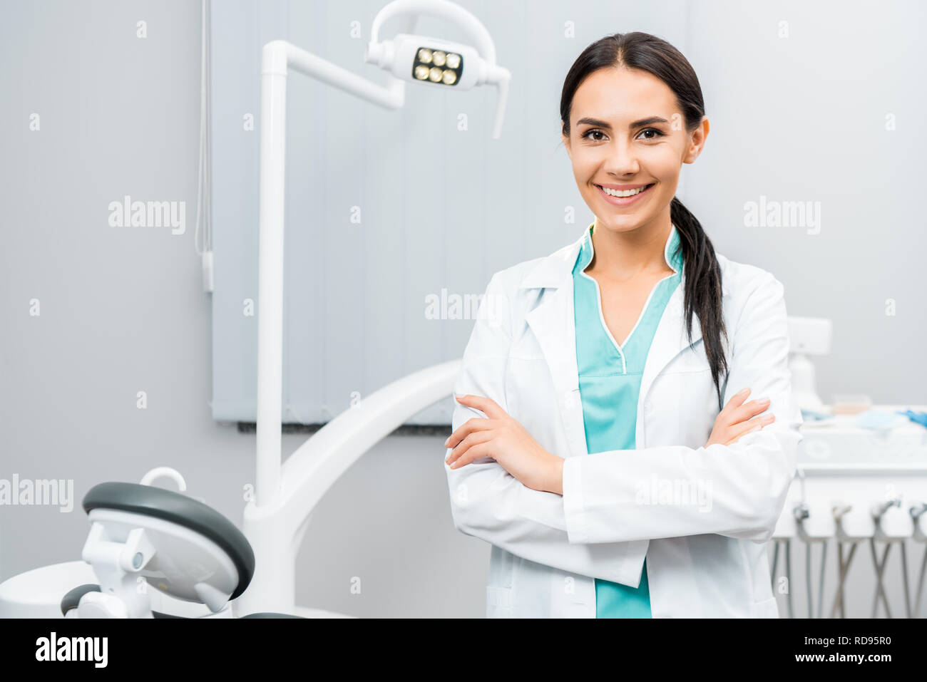beautiful dentist standing with crossed arms in dental clinic Stock ...