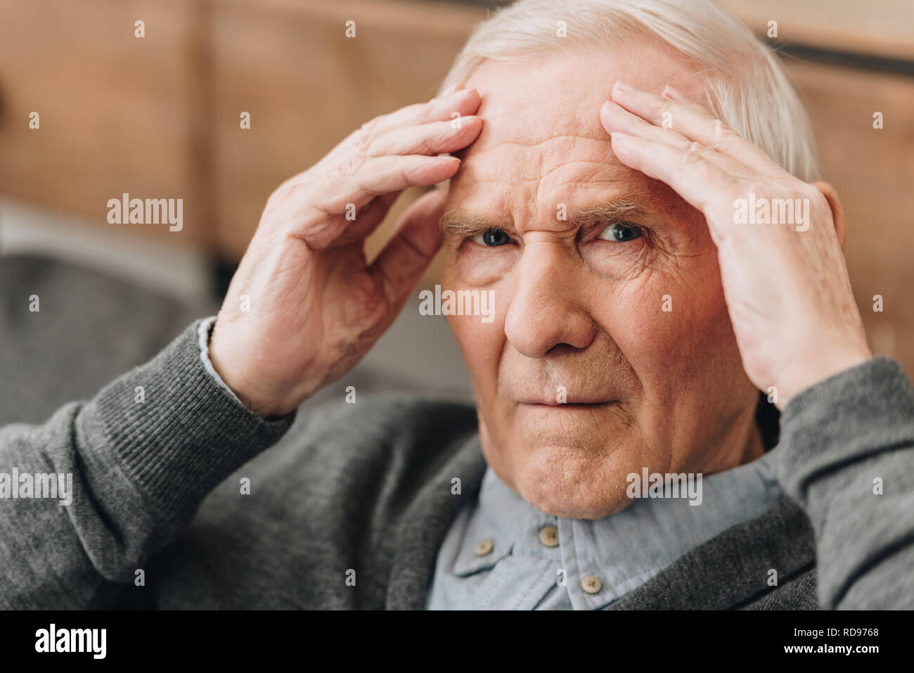 retired man holding head while having headache Stock Photo - Alamy