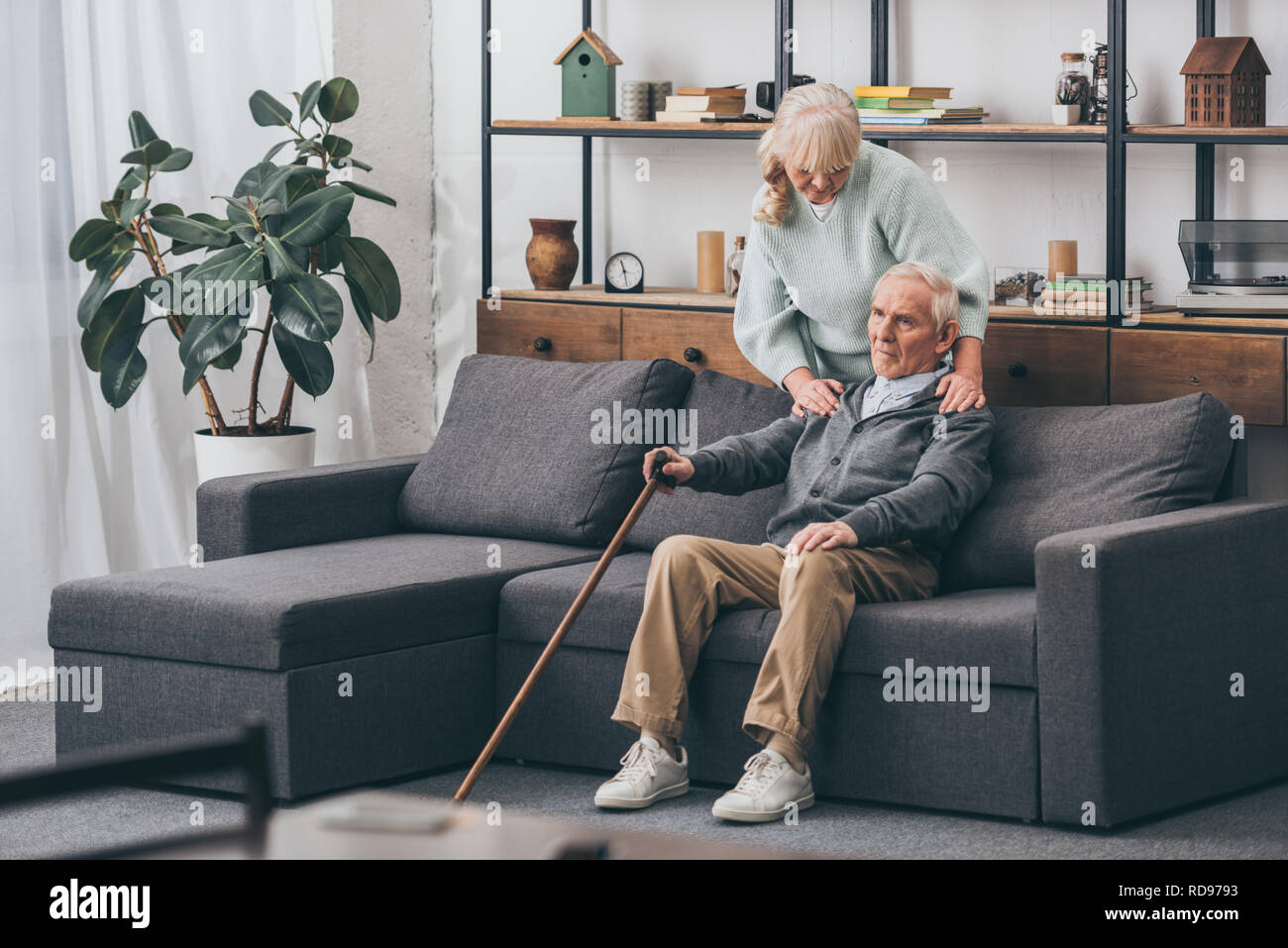 retired wife embrace sad senior husband sitting with walking cane in ...