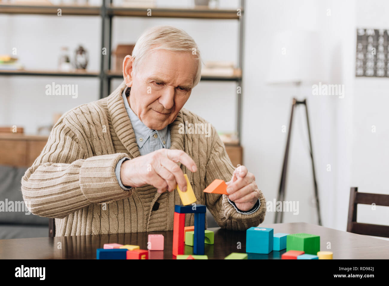 retired man playing with wooden toys at home Stock Photo - Alamy
