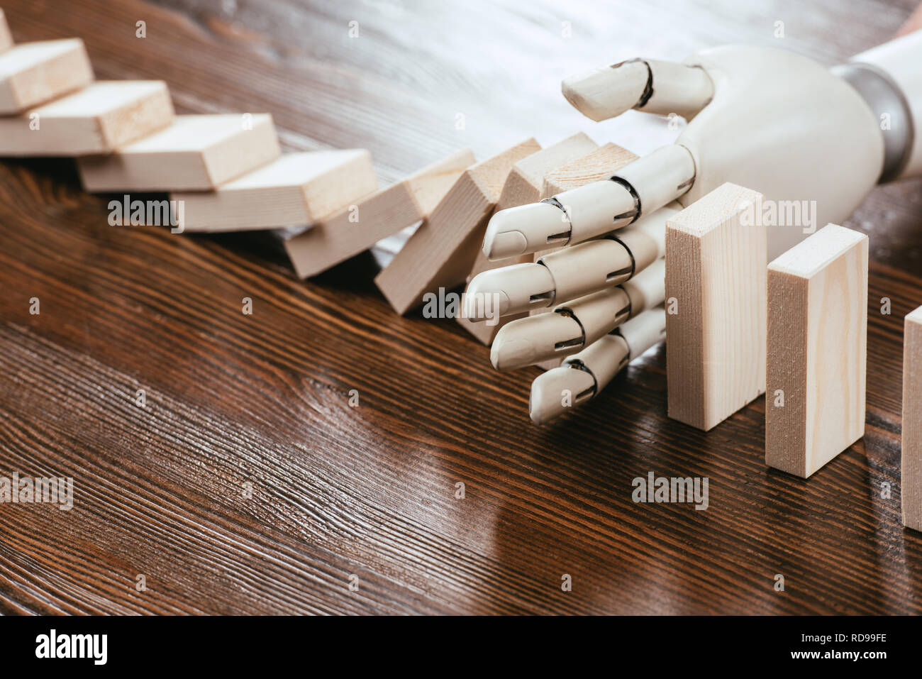 robotic hand preventing wooden blocks from falling on desk with copy ...