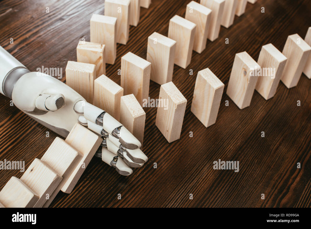 robotic hand preventing wooden blocks from falling on desk Stock Photo ...
