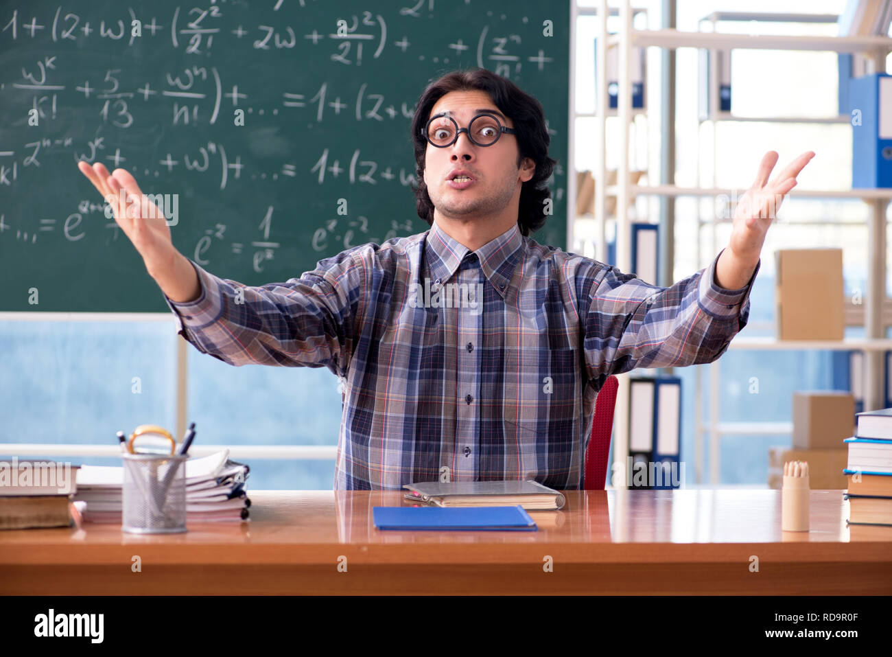Young funny math teacher in front of chalkboard Stock Photo - Alamy