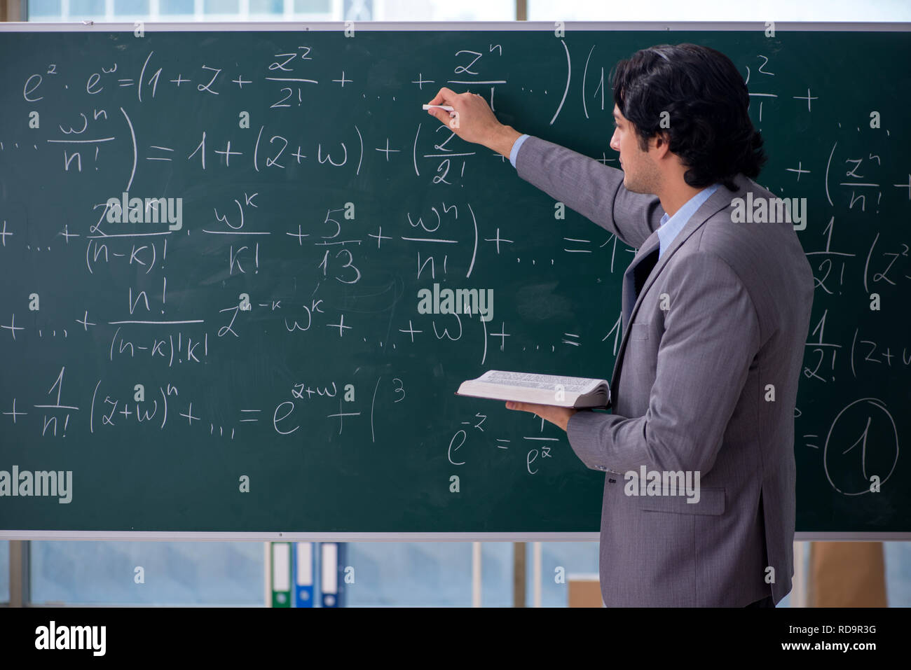 Young handsome math teacher in classroom Stock Photo - Alamy