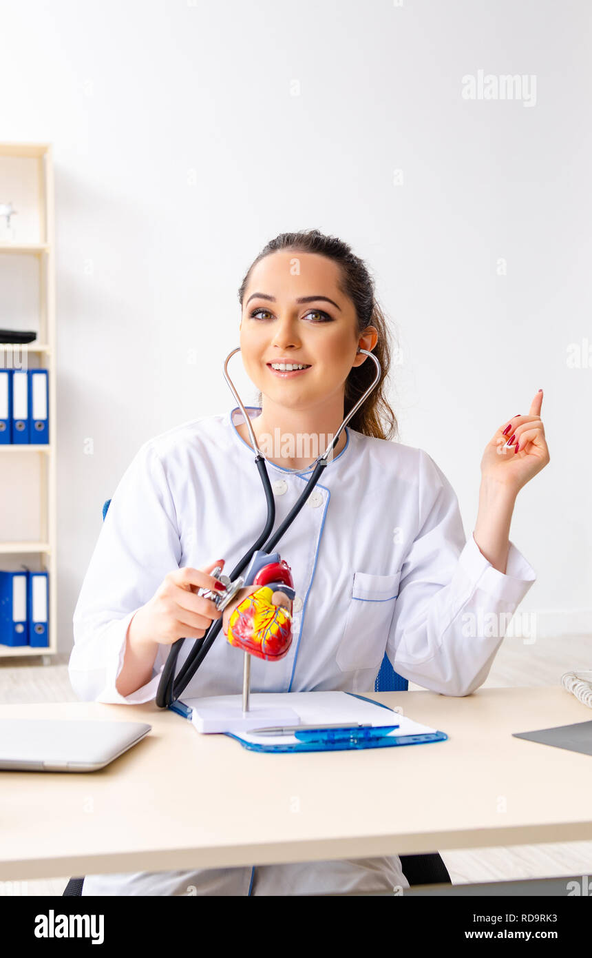 Young female doctor cardiologist sitting at the hospital Stock Photo ...
