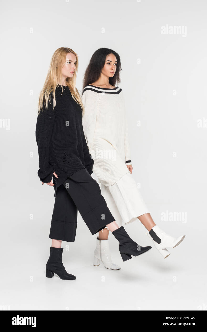 beautiful multicultural women in black and white clothes walking on ...