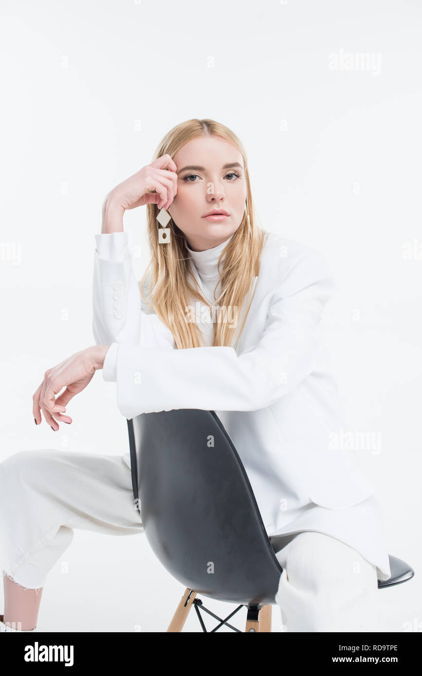 Attractive Caucasian Blonde Woman In Fashionable White Clothes Sitting