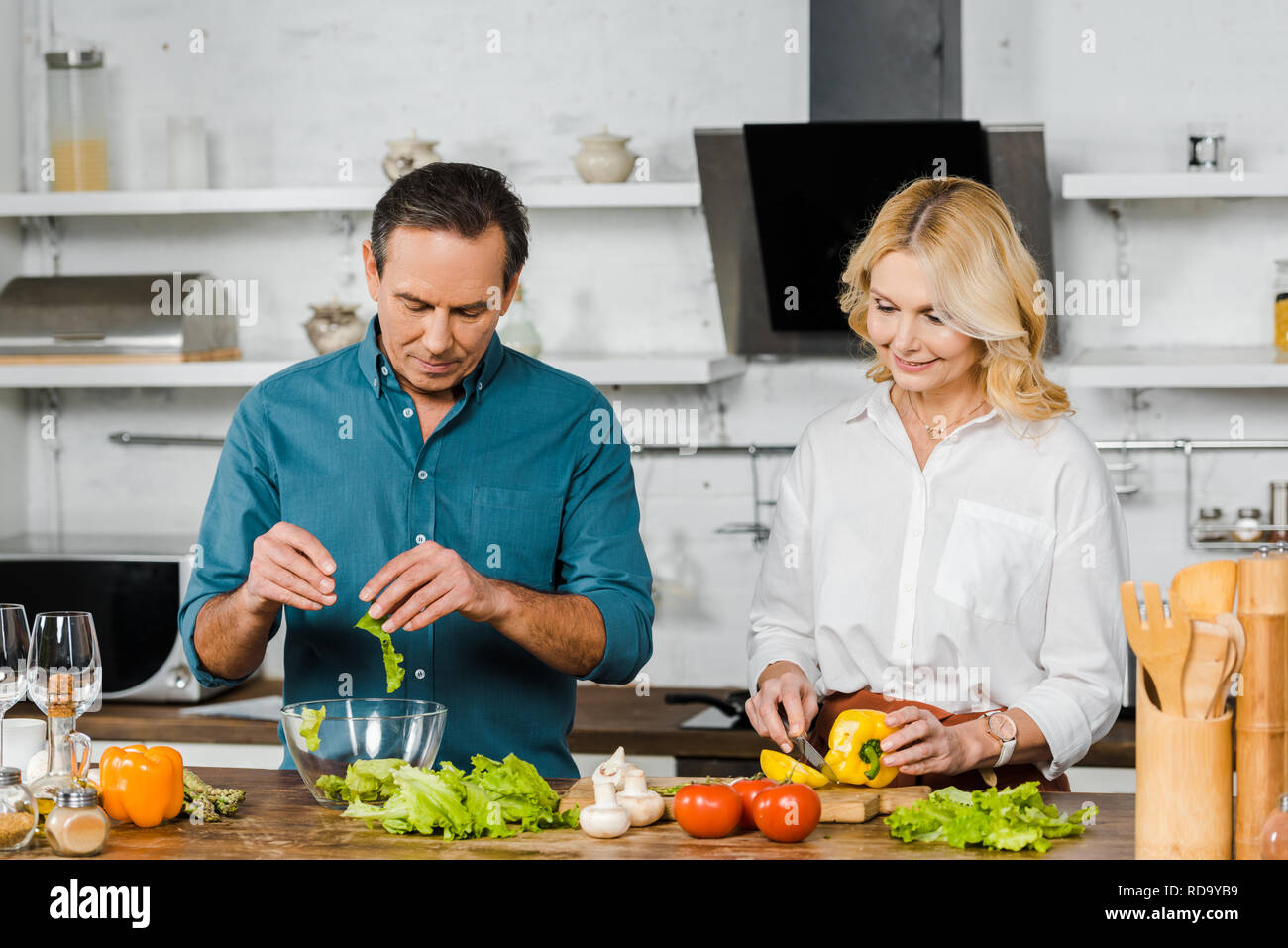 mature wife and husband cooking salad together in kitchen Stock Photo ...