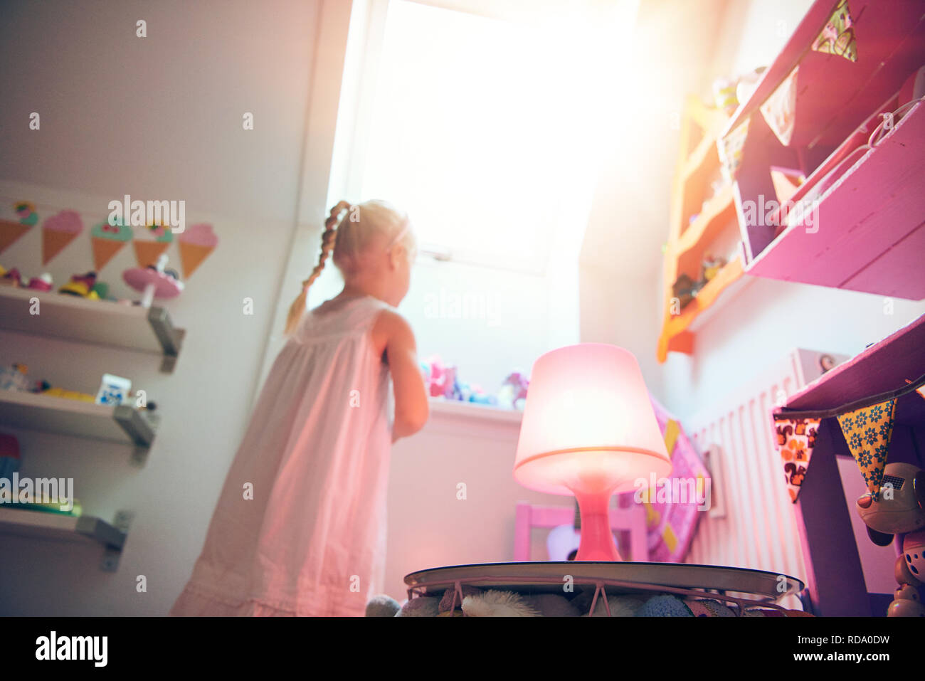 Back view of girl looking at window in her bedroom. Horizontal indoors ...