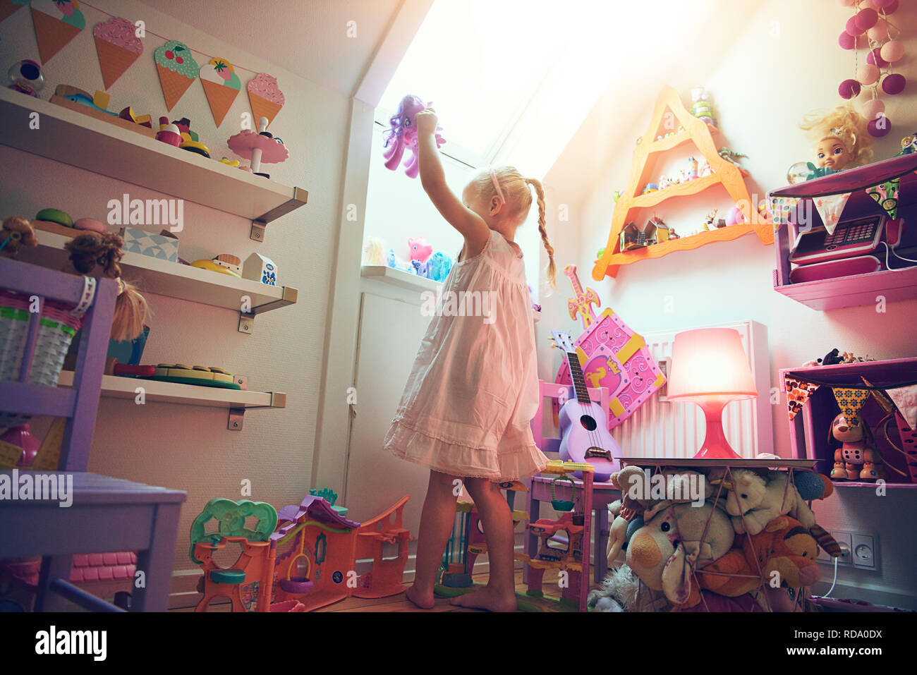 Back view of little girl playing with her colorful toys. Horizontal ...