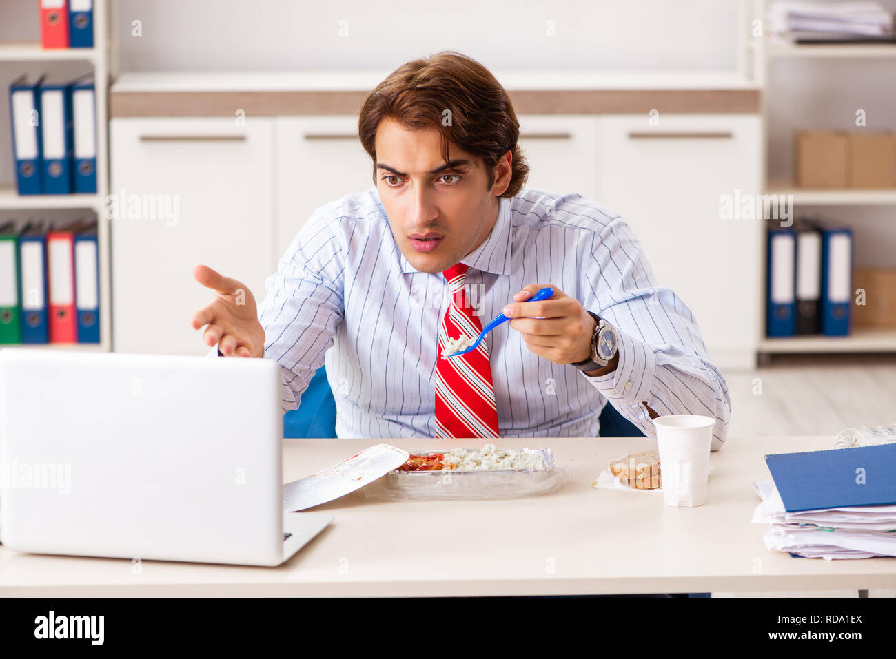 Man having meal at work during break Stock Photo - Alamy