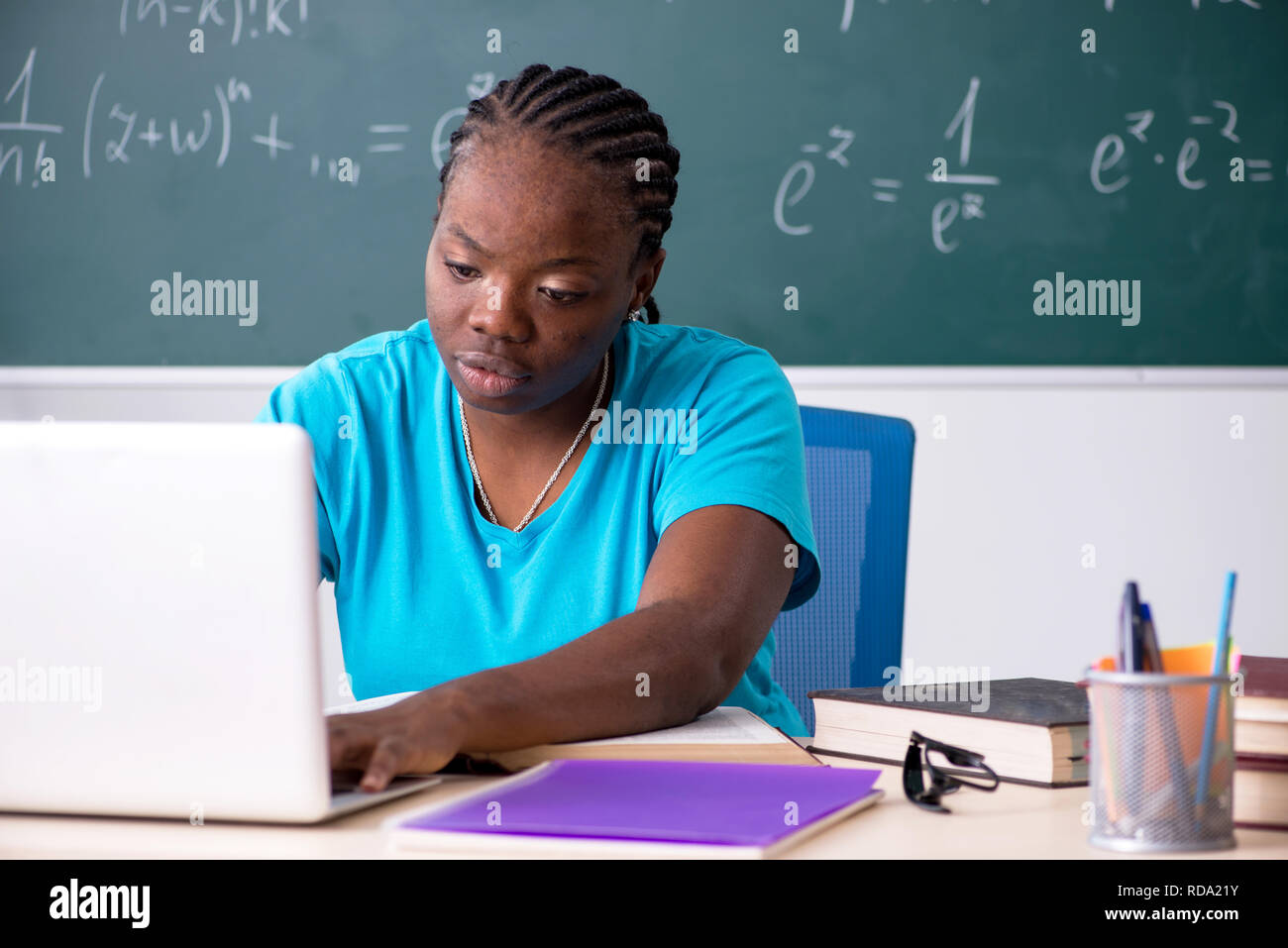 Black female student in front of chalkboard Stock Photo - Alamy
