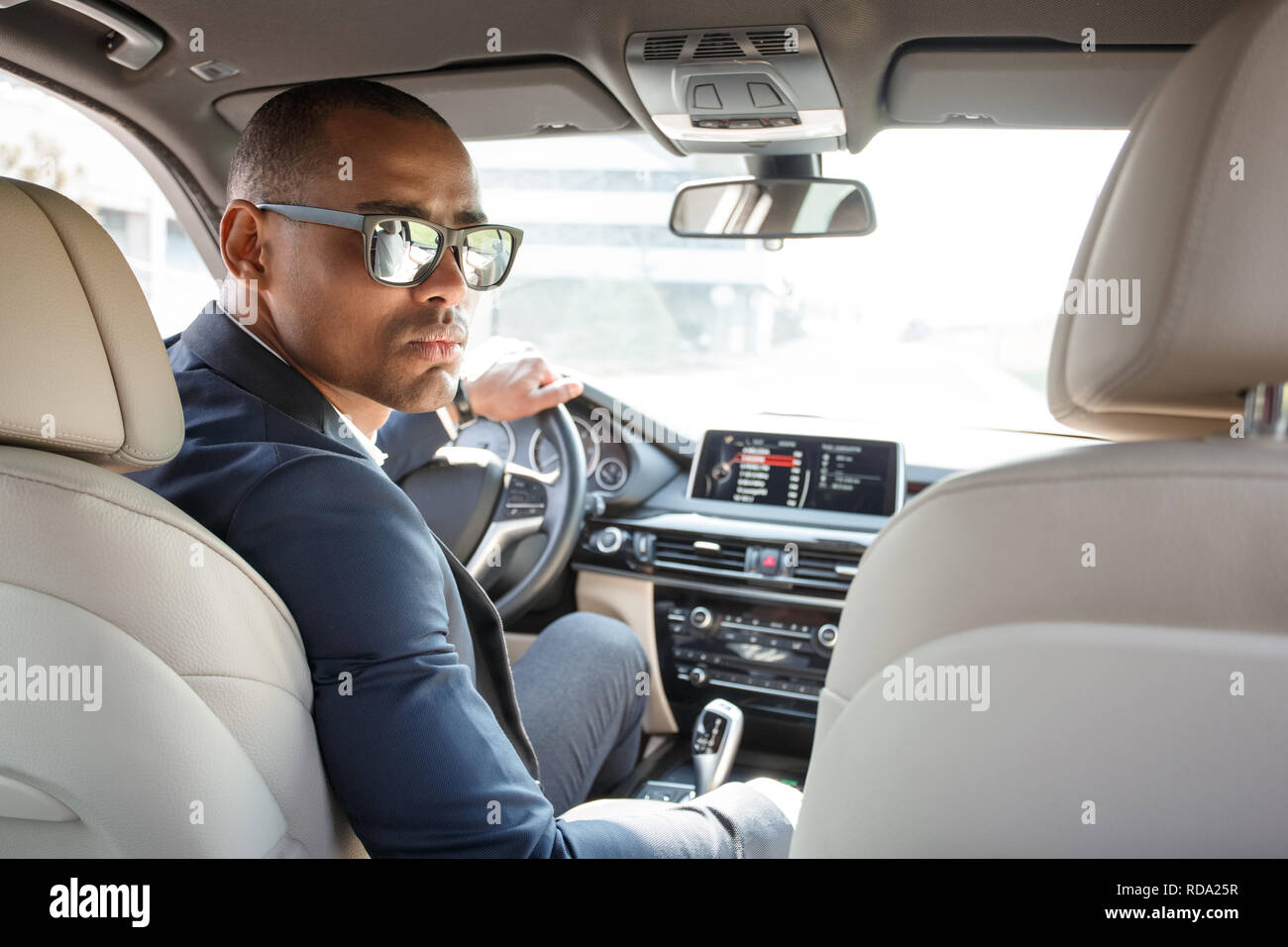 Young security guard driver in sunglasses sitting inside car looking ...