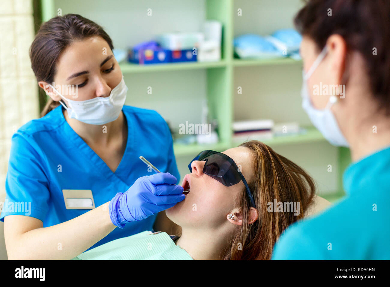Beautiful young woman having dental treatment at dentist's office ...