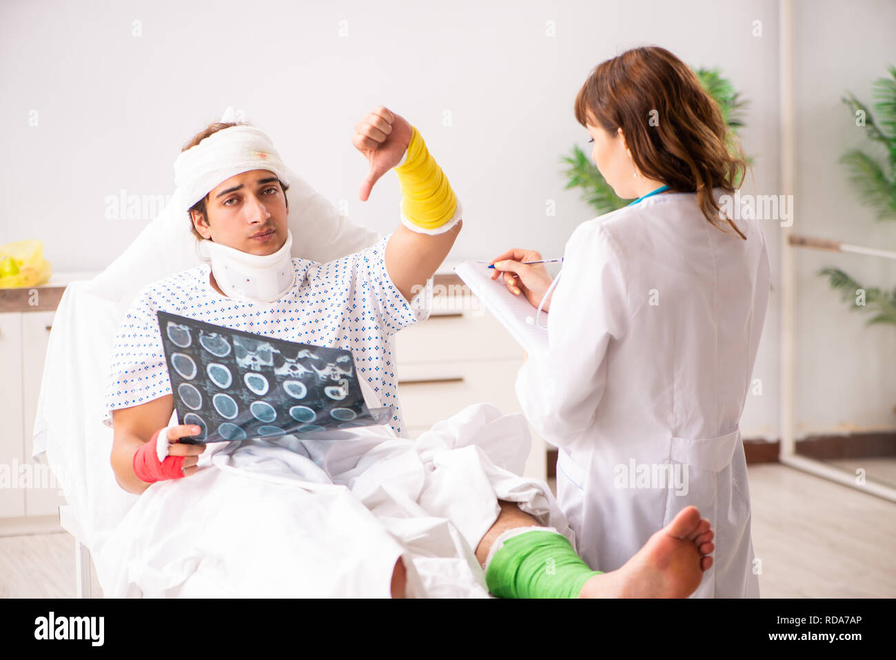 Young doctor examining injured patient Stock Photo - Alamy