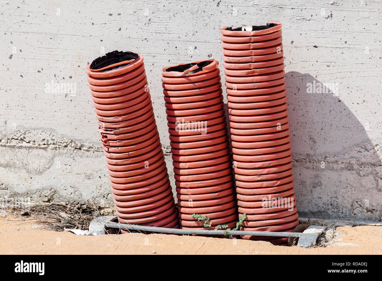 Red orange corrugated sheath for electric cables, on a building ...