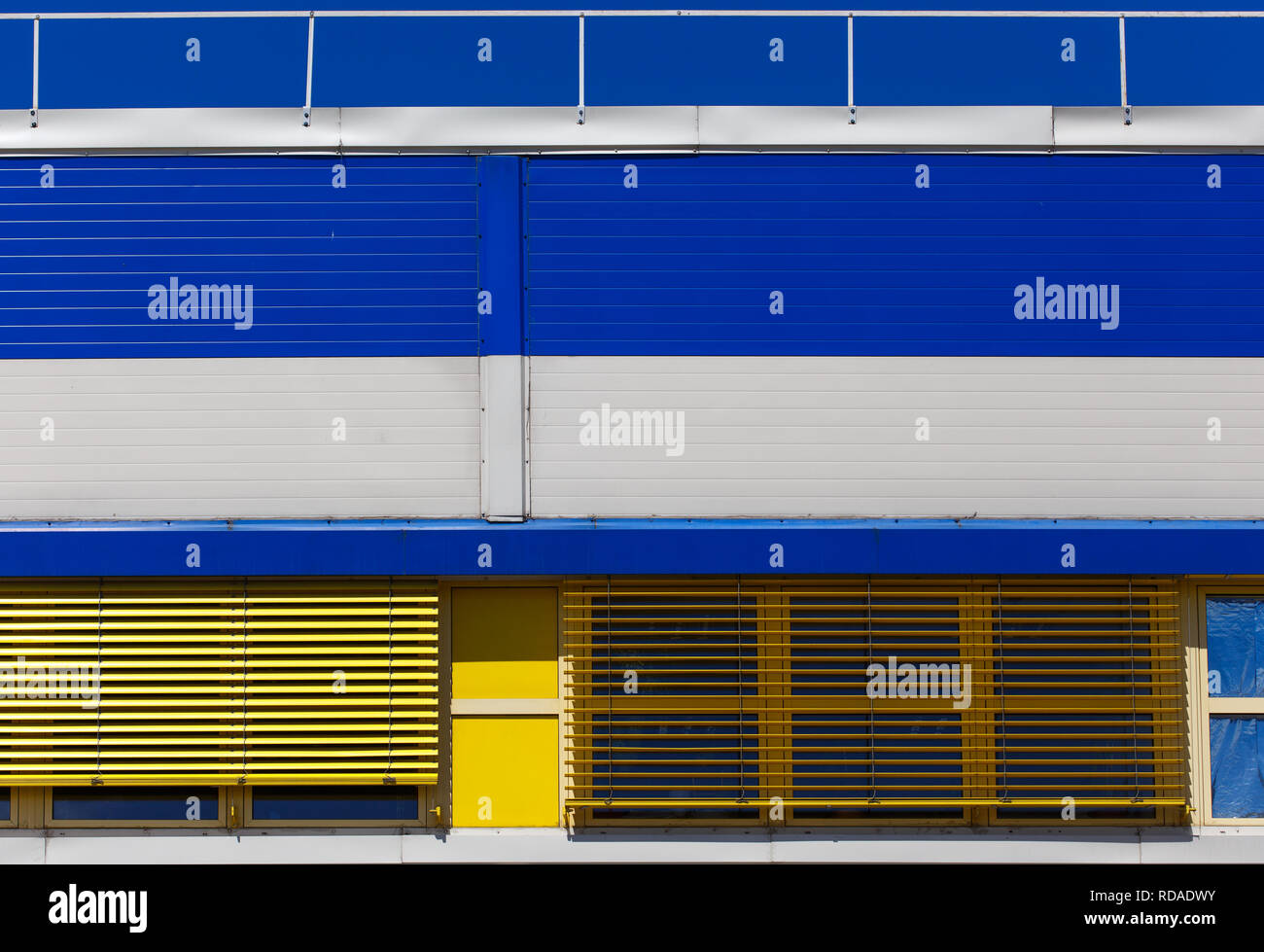 Industrial building with blue and yellow metal siding trim. Abstract ...