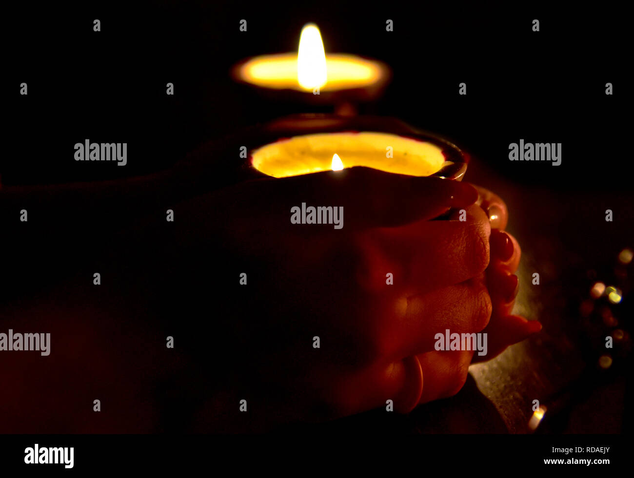 Women's hand holding a burning red candle in the dark light Stock Photo ...