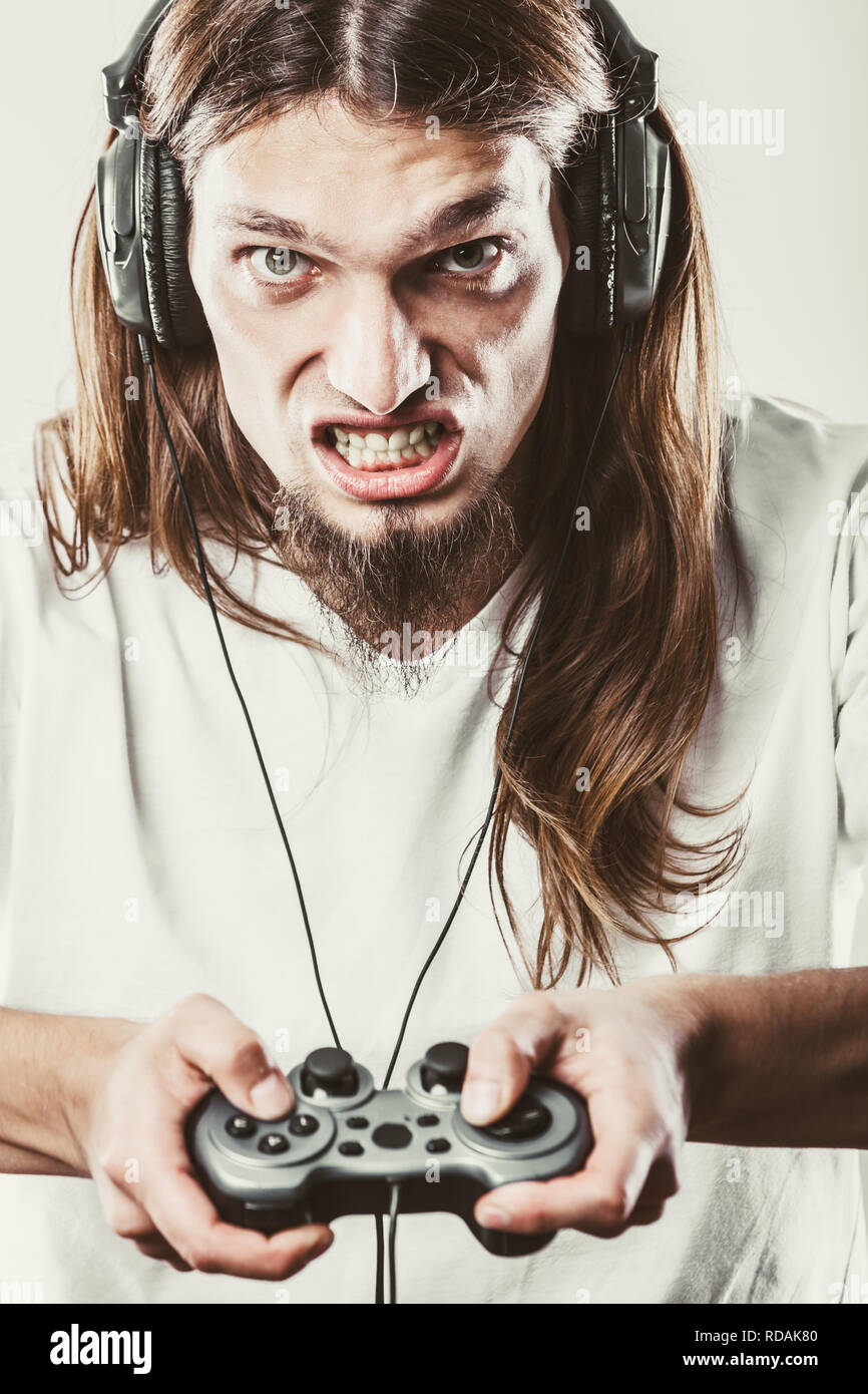 Addiction. Stressed depressed young man playing gaming on pad. Angry ...