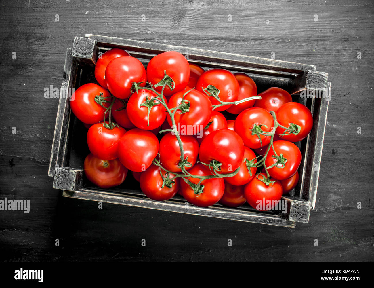 Green red tomatoes in a vegetable box and a black hi-res stock ...