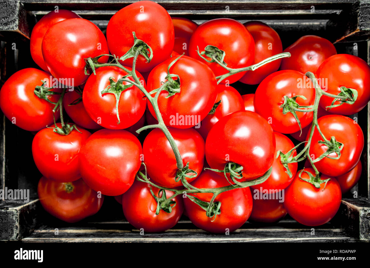 Green red tomatoes in a vegetable box and a black hi-res stock ...