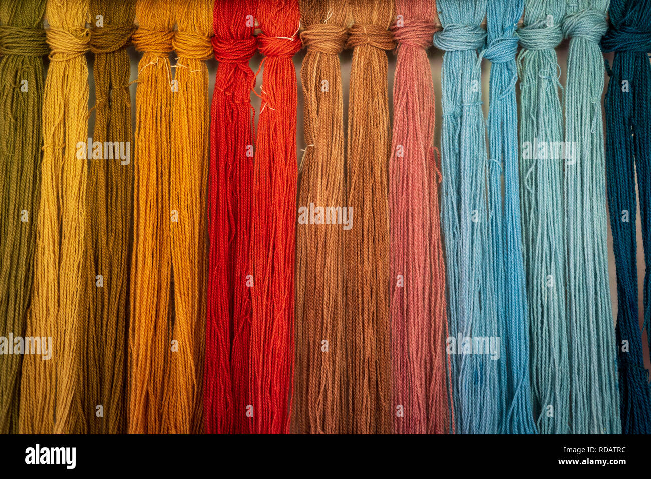 Colorful Yarn hanging from a dowl rod Stock Photo - Alamy