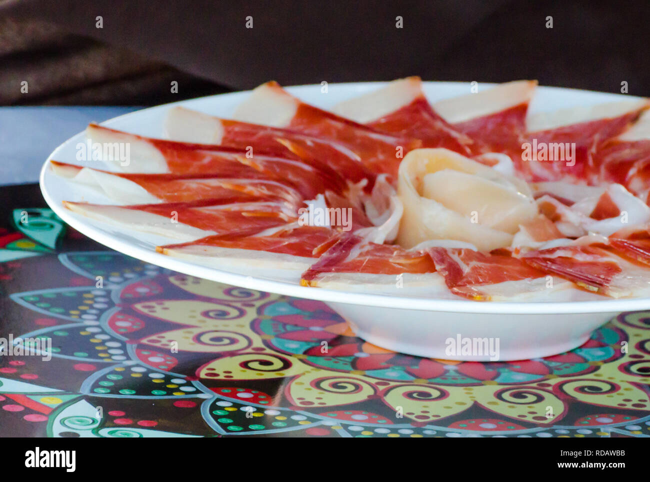 plate with cut slices of jamon serrano, traditional Spanish ham, meat ...
