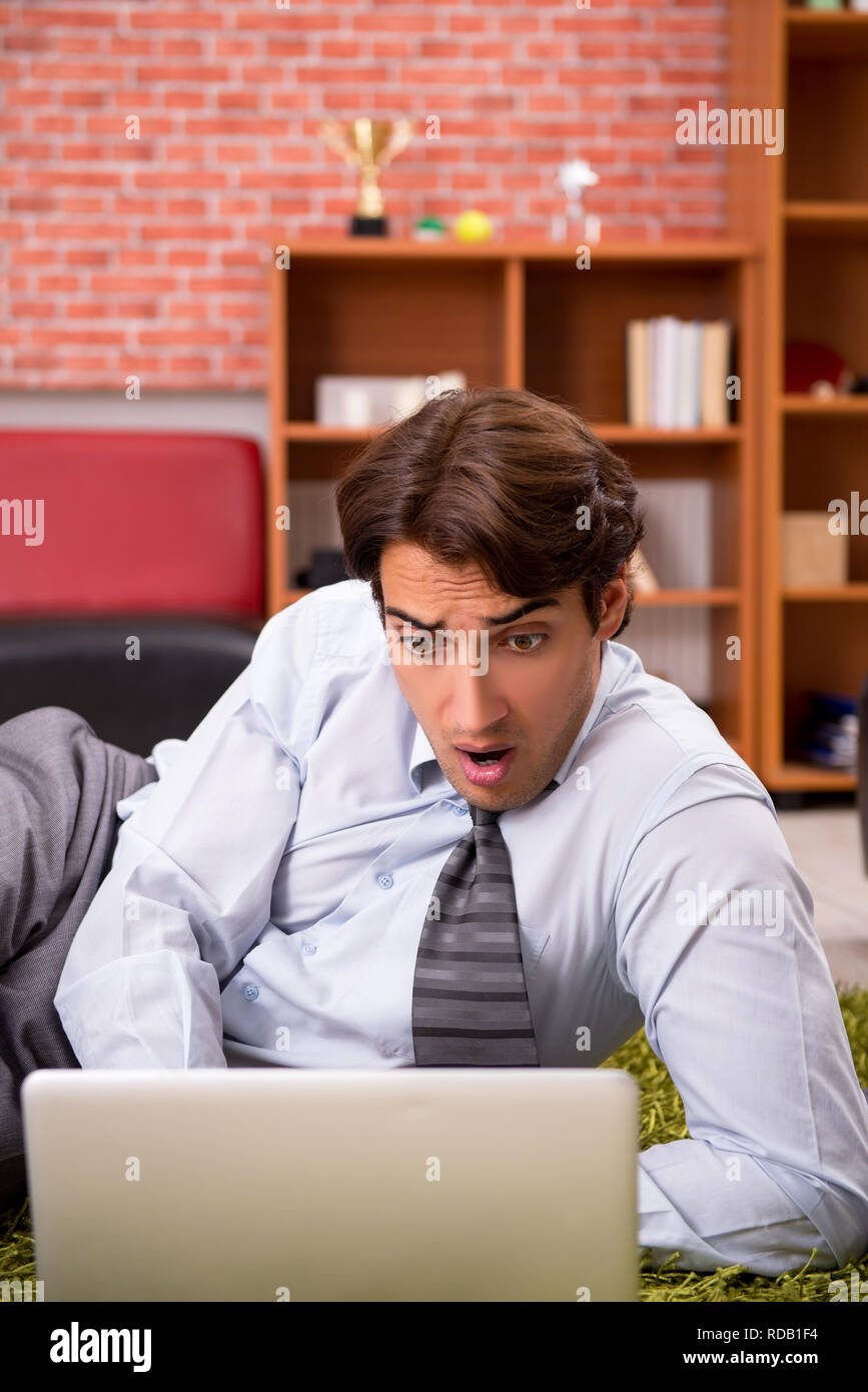 Young employee lying on the floor at office Stock Photo - Alamy